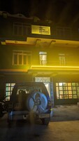 Um veículo estacionado em frente a um edifício com uma placa indicando "THE HOTEL NANGLO".