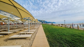 Uma praia privada, espreguiçadeiras, guarda-sóis de praia