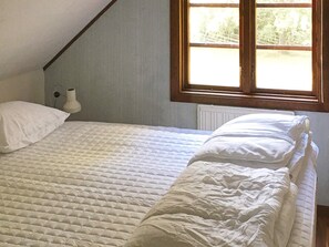 Quarto com cama, janela e radiador.