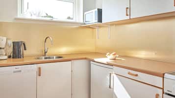 Cozinha compacta com lava-louças, micro-ondas e pia.