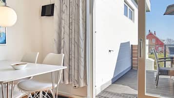 Um interior moderno com área de jantar, televisão e vista para o exterior.