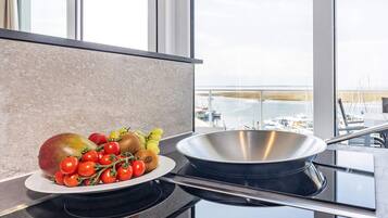 Uma bancada de cozinha com uma travessa de frutas e uma panela de aço inoxidável.