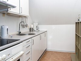 Uma cozinha compacta com fogão, pia e armários.