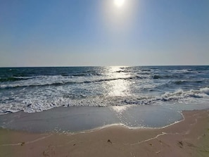 Uma praia com ondas e céu claro.