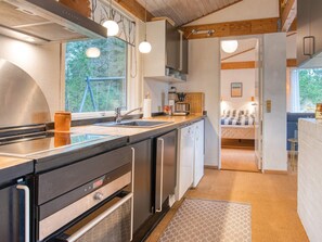 Uma cozinha moderna com forno embutido, lava-louças e uma grande janela com vista para o exterior.