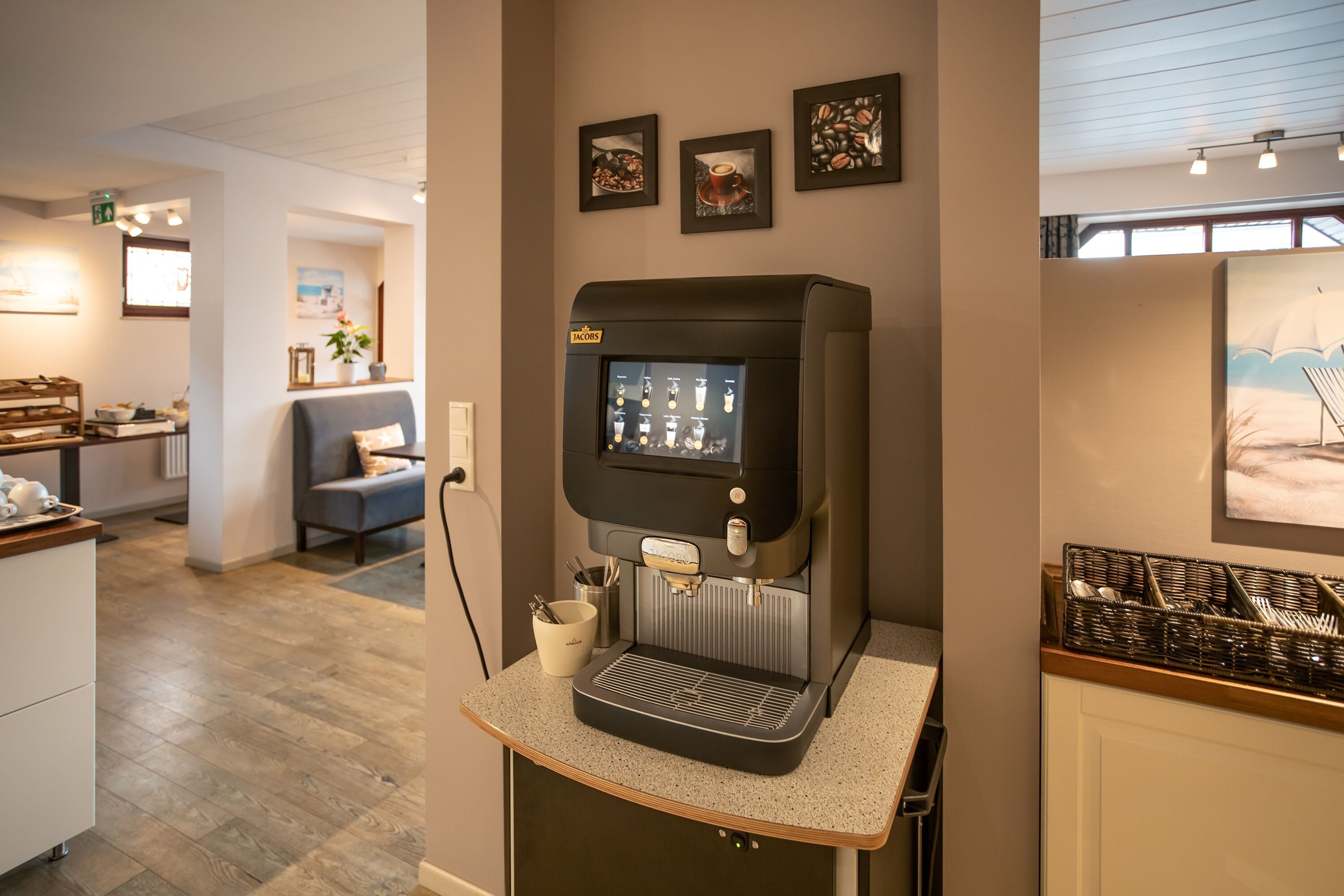 Máquina de café em café moderno, com balcão, área de estar e obras de arte nas paredes.