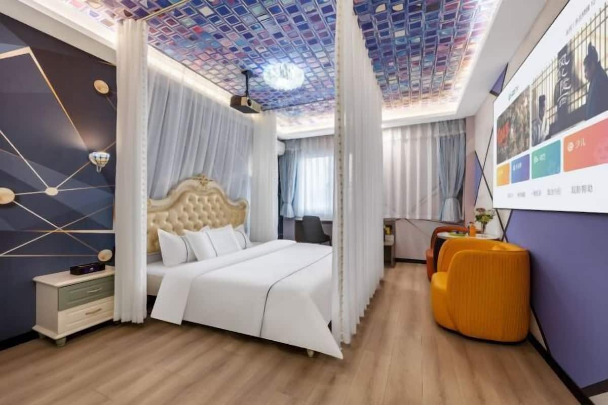 Quarto de hotel moderno com uma cama grande, uma escrivaninha e um espaço de estar.