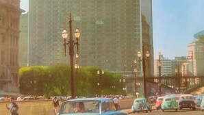 Um edifício alto com uma placa que diz 'COCA COLA' na fachada.