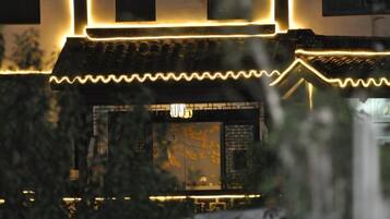Edifício tradicional com detalhes arquitetônicos iluminados e entrada visível.