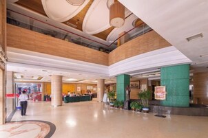 Um hall amplo com pé direito alto, vários níveis e uma área de estar central.
