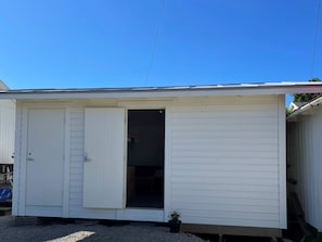 Um edifício térreo com uma porta fechada e uma porta de garagem aberta.