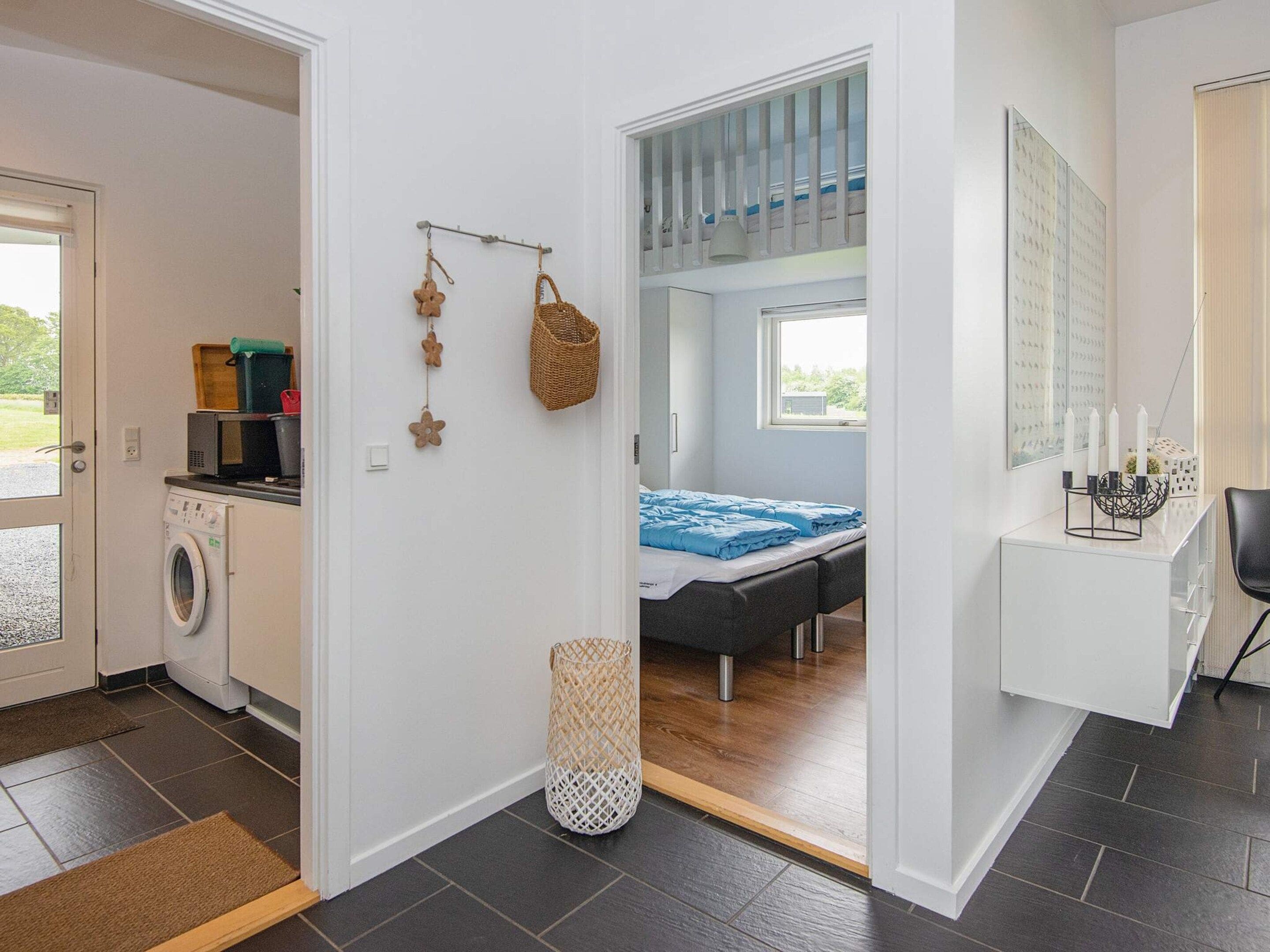 Quarto moderno com cama, escrivaninha e vista para um jardim pela janela.