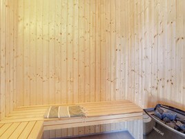 Uma sauna com banco, toalha e aquecedor de pedra.