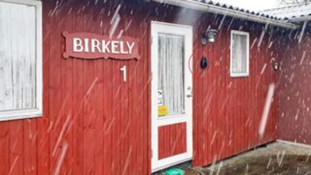 Um edifício vermelho com porta branca e uma placa que diz 'BIRKELY 1'.