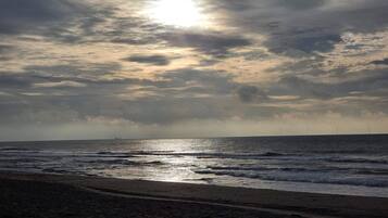 Uma praia com ondas e céu nublado.