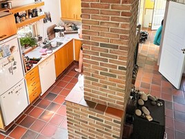 Cozinha com parede de tijolos, geladeira e pia.