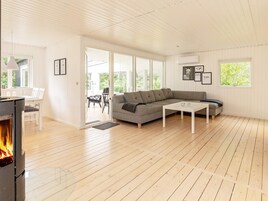 Uma sala de estar moderna com um sofá seccional, uma mesa de centro e uma lareira.