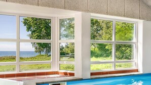 A swimming pool with a view of the sea and greenery.