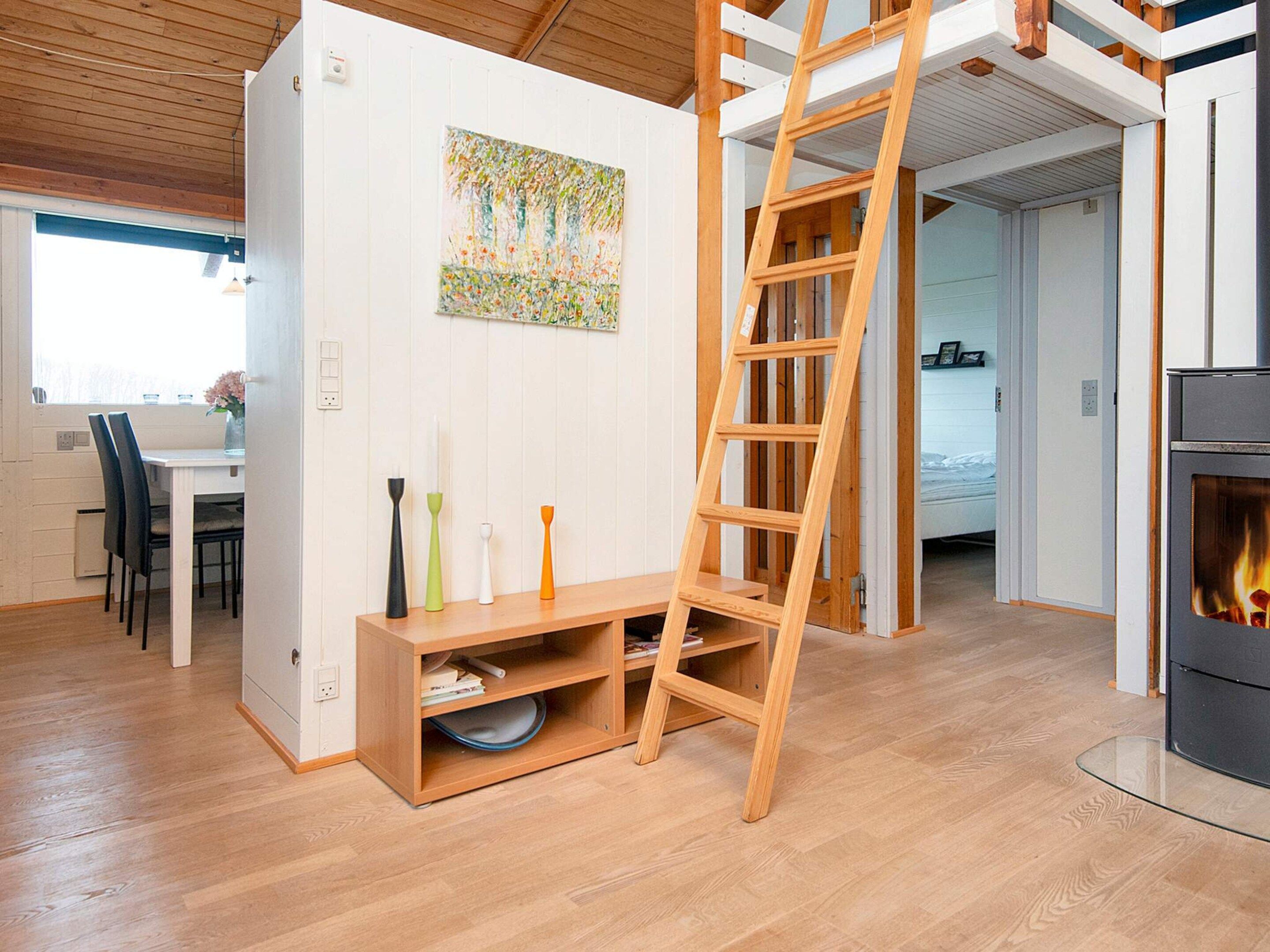 Um interior moderno com escada de madeira, área de refeições e lareira.