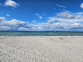 Uma praia com céu claro e oceano.