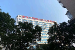 Um edifício com vários andares, fachada plana e grandes janelas.