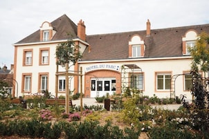 Um edifício de dois andares com uma placa que diz 'HOTEL DU PARC'.
