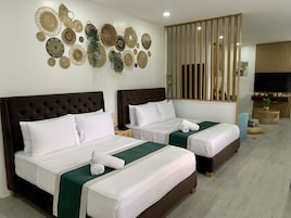 Quarto de hotel com duas camas, um espelho grande e arte decorativa na parede.