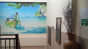 Corredor com um mural de um barco na água, escada e sinal de saída de incêndio.
