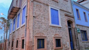 Um edifício de pedra com várias janelas e uma porta.