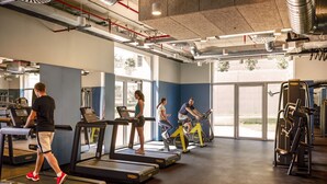 Uma academia com esteiras, bicicletas ergométricas e aparelhos de musculação.