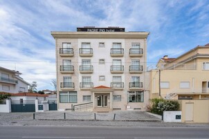Um hotel com vários andares, com um letreiro que diz "Padre Pio hotel" no topo.