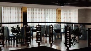 Um interior moderno com uma área de refeições, uma escadaria e vista para o exterior.