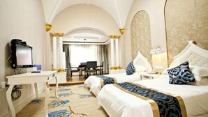Quarto de hotel com duas camas, uma escrivaninha, televisão e vista para o corredor.