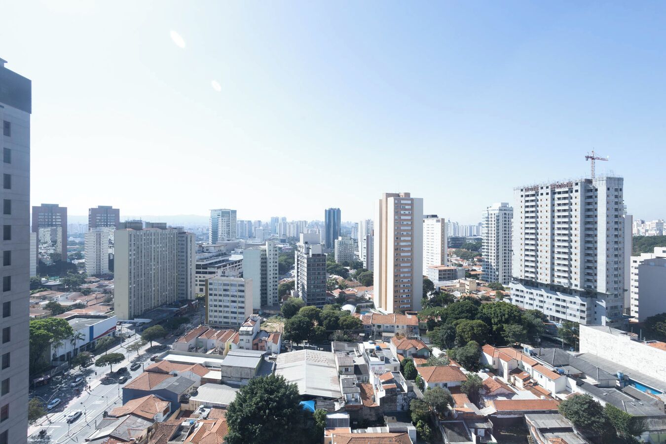 Paisagem urbana com edifícios altos, uma combinação de estruturas residenciais e comerciais, e céu claro.