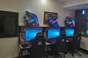 Uma configuração de jogos com vários monitores, iluminação RGB e cadeiras gamer.