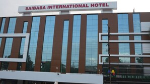 Um edifício moderno com uma placa que diz 'SAIBABA INTERNATIONAL HOTEL'.