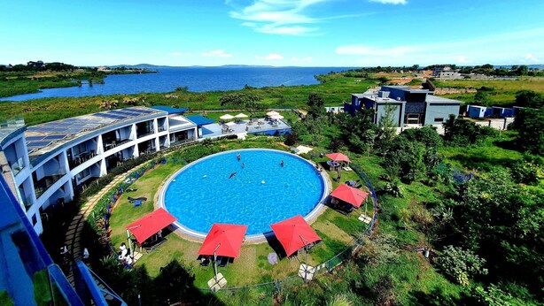 Um resort com piscina central, espreguiçadeiras e vista para o mar.