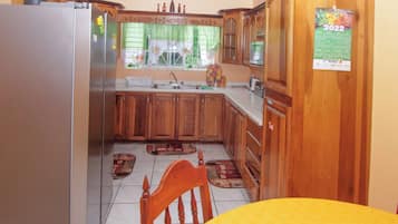 Um frigorífico, um micro-ondas, forno de mesa, utensílios de cozinha