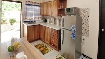 Um frigorífico, um micro-ondas, forno de mesa, utensílios de cozinha
