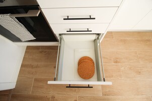 Uma cafeteira/bule, um frigorífico, um micro-ondas, um forno