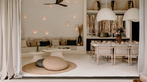 Uma sala de estar moderna com sofá, mesa de centro e área de refeições.