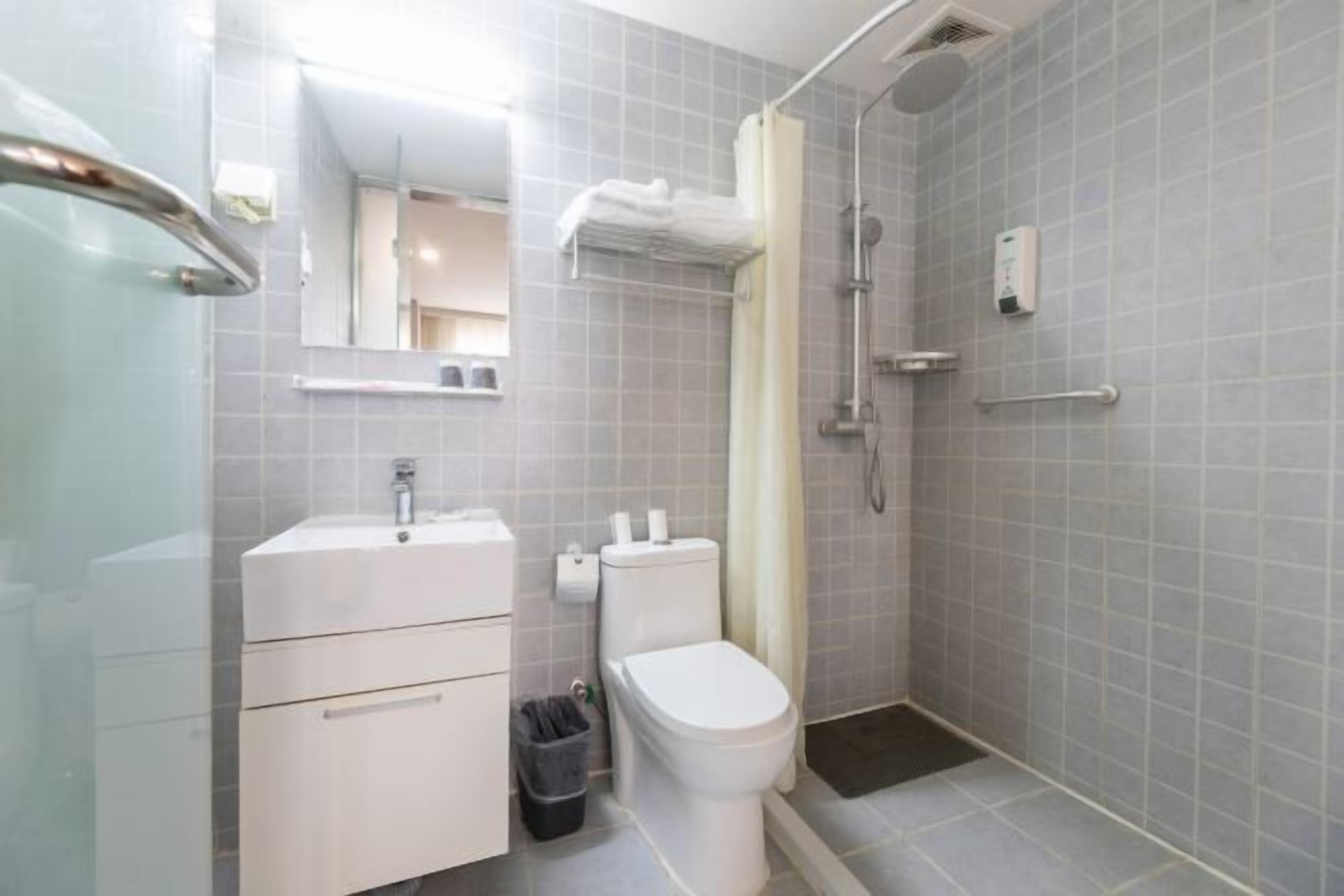 Uma casa de banho moderna com sanita, lavatório e chuveiro.