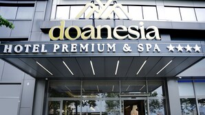 A entrada de um hotel chamado 'doanasia', com uma placa indicando que é um 'HOTEL PREMIUM & SPA'.