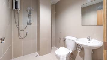 Uma casa de banho moderna com chuveiro, sanita e lavatório.
