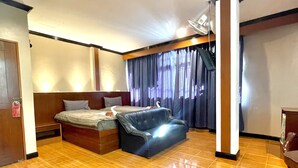 Quarto de hotel espaçoso com uma cama grande, um sofá e um espaço de estar separado.