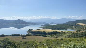 Vista panorâmica de um lago rodeado por colinas e campos.