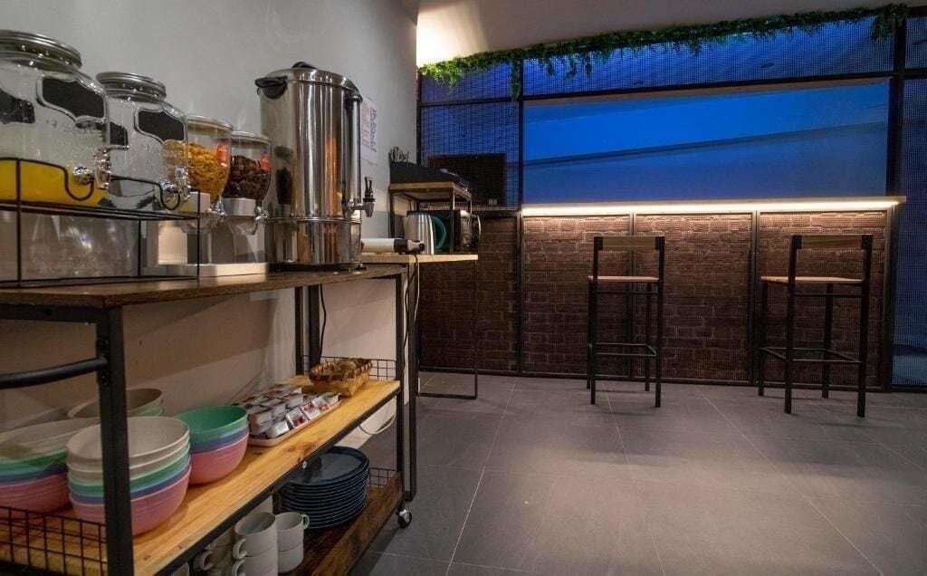 Uma cozinha moderna com parede de tijolos, área de bar com banquetas e janela com vista.