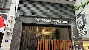 Entrada de um apartamento com serviço, com um portão de metal, uma placa e uma placa com o número 13.