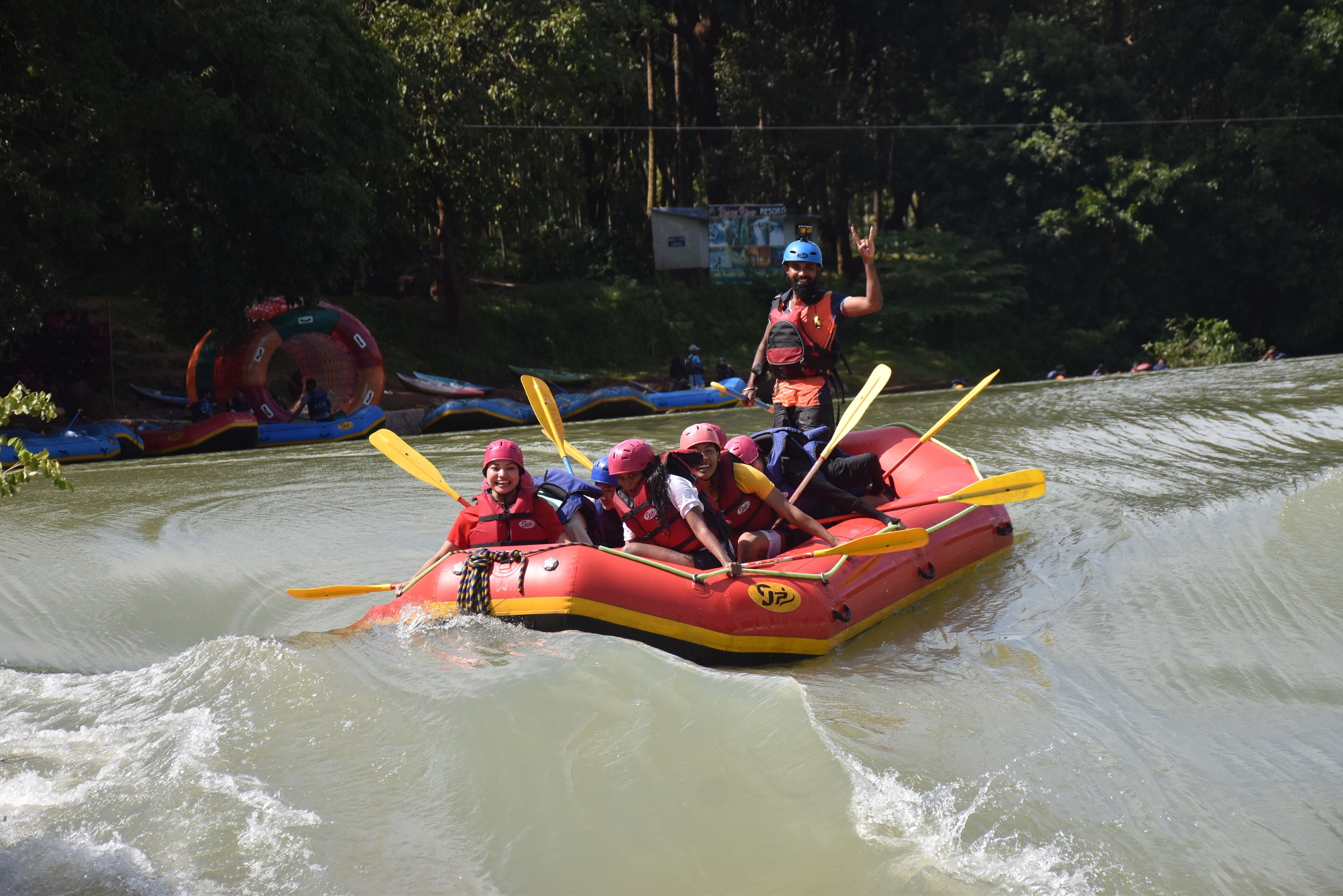 Um grupo de pessoas em um bote inflável vermelho em um rio.