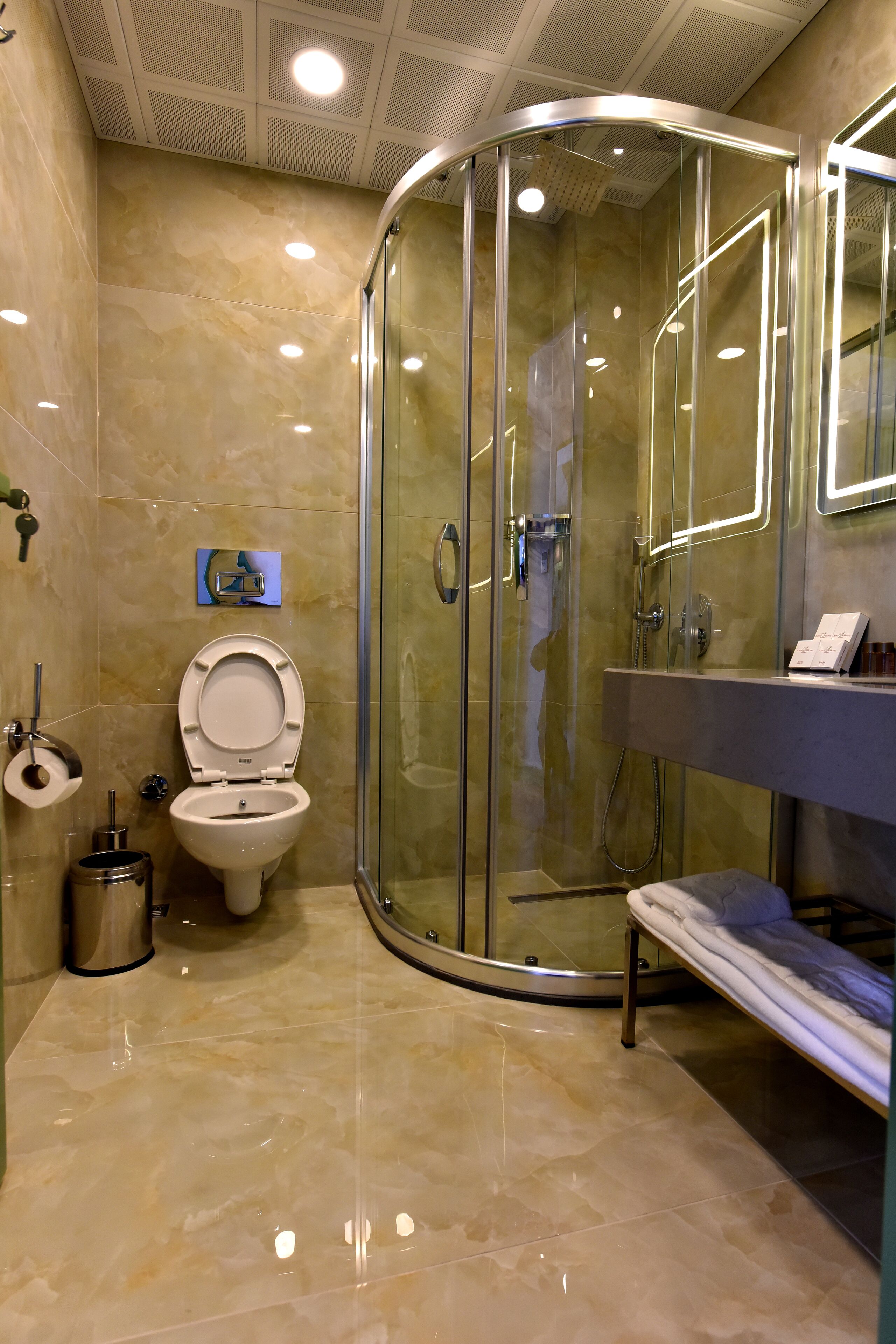 Uma casa de banho moderna com chuveiro envidraçado, sanita e toucador com espelho.